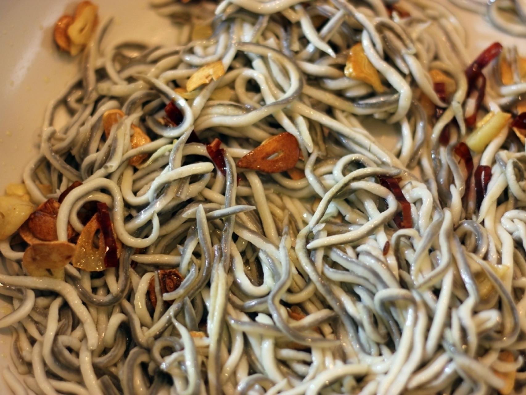 Pizzas negras de gulas al ajillo